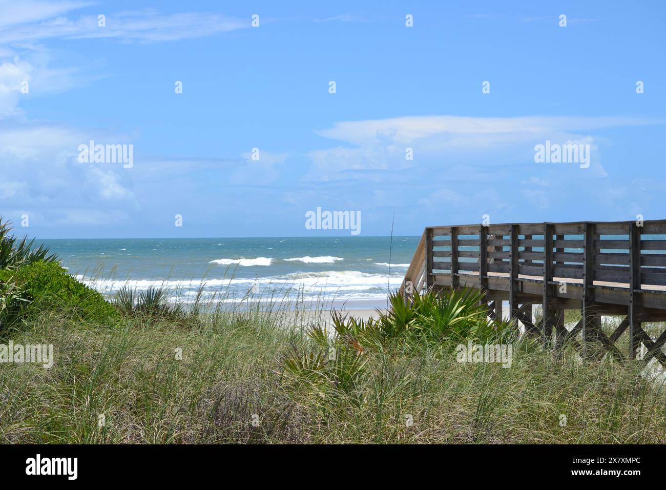 A wooden walkway, running alongside the dunes, leads to the beach and ...