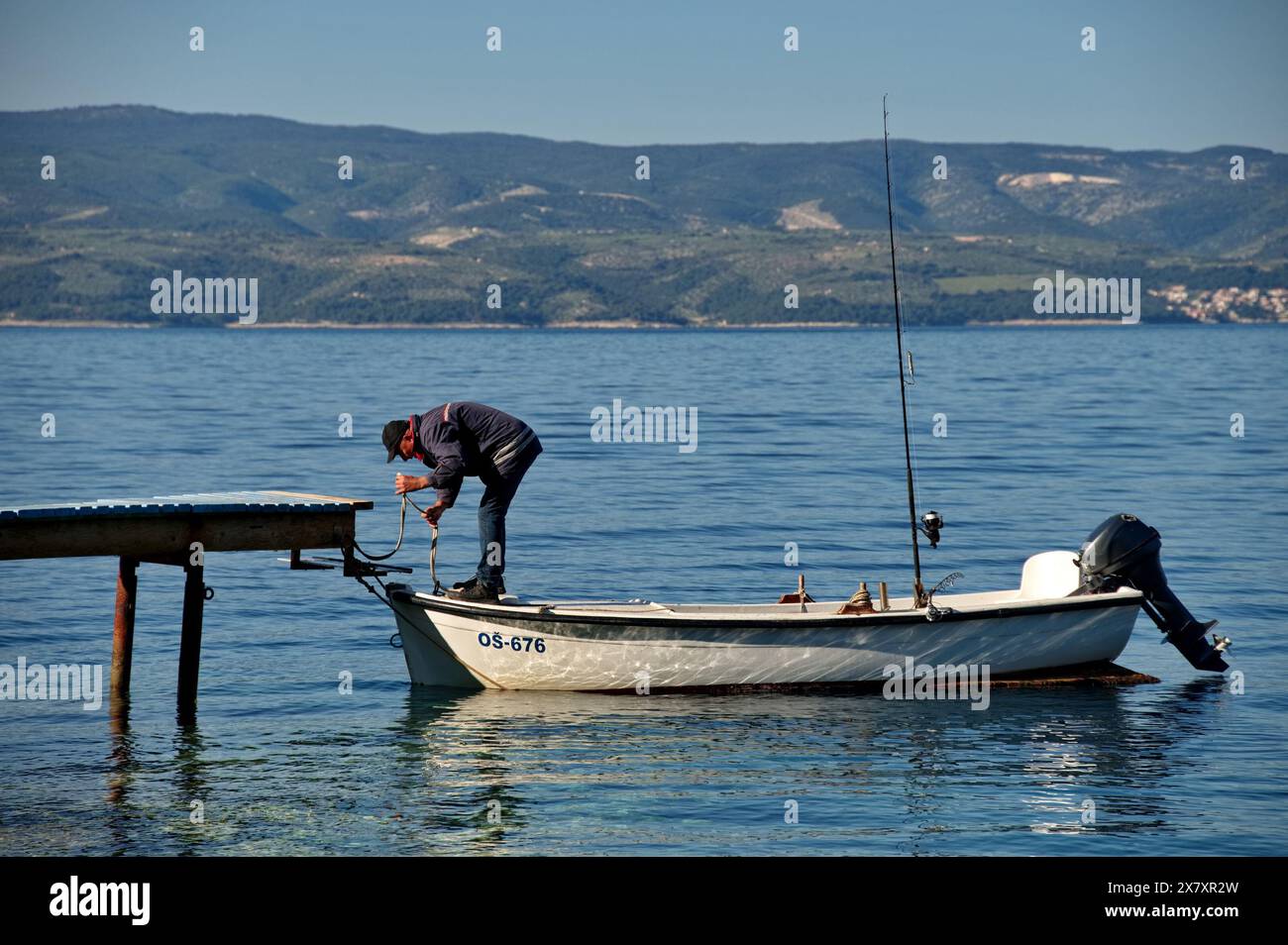 An old fisherman moors a boat Stock Photo - Alamy