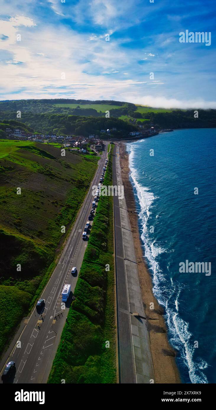 Aerial view of a coastal road with cars, adjacent to a beach and ocean ...