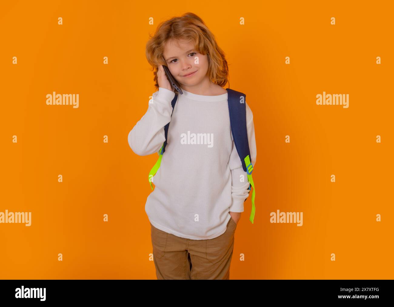 Child using mobile phone, tell, talk on the phone over yellow ...
