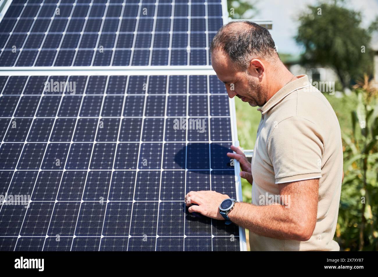 Adult man controling operation of solar cells. Male looking at his new ...