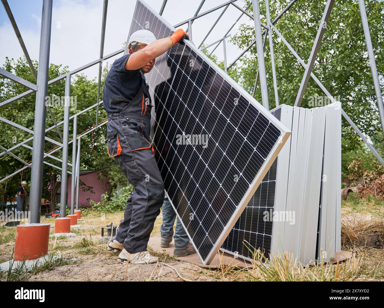Workers carrying solar panels for installing in field. Technicians ...