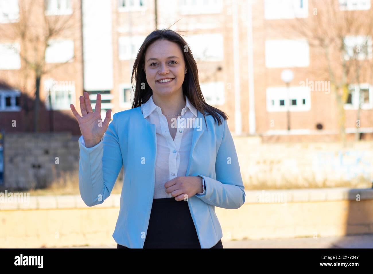 Formal dress happy business woman is waving her hand outdoors, look at ...