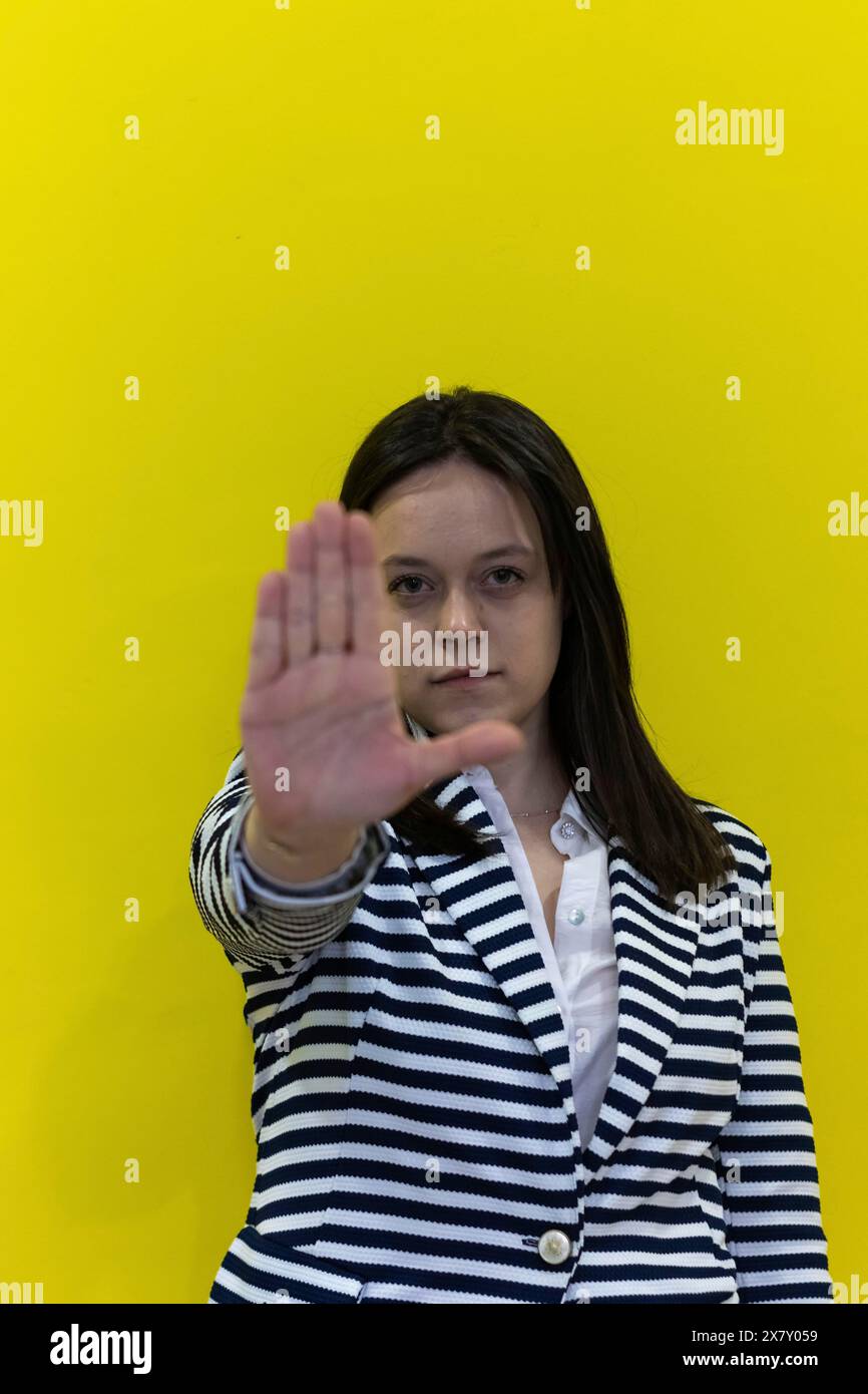 Vertical close-up of a woman extending her hand with a serious stop ...