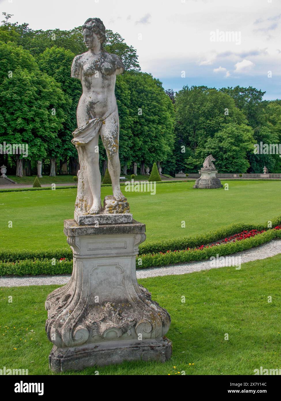 Weathered statue in a well-kept park with green lawns and surrounded by ...