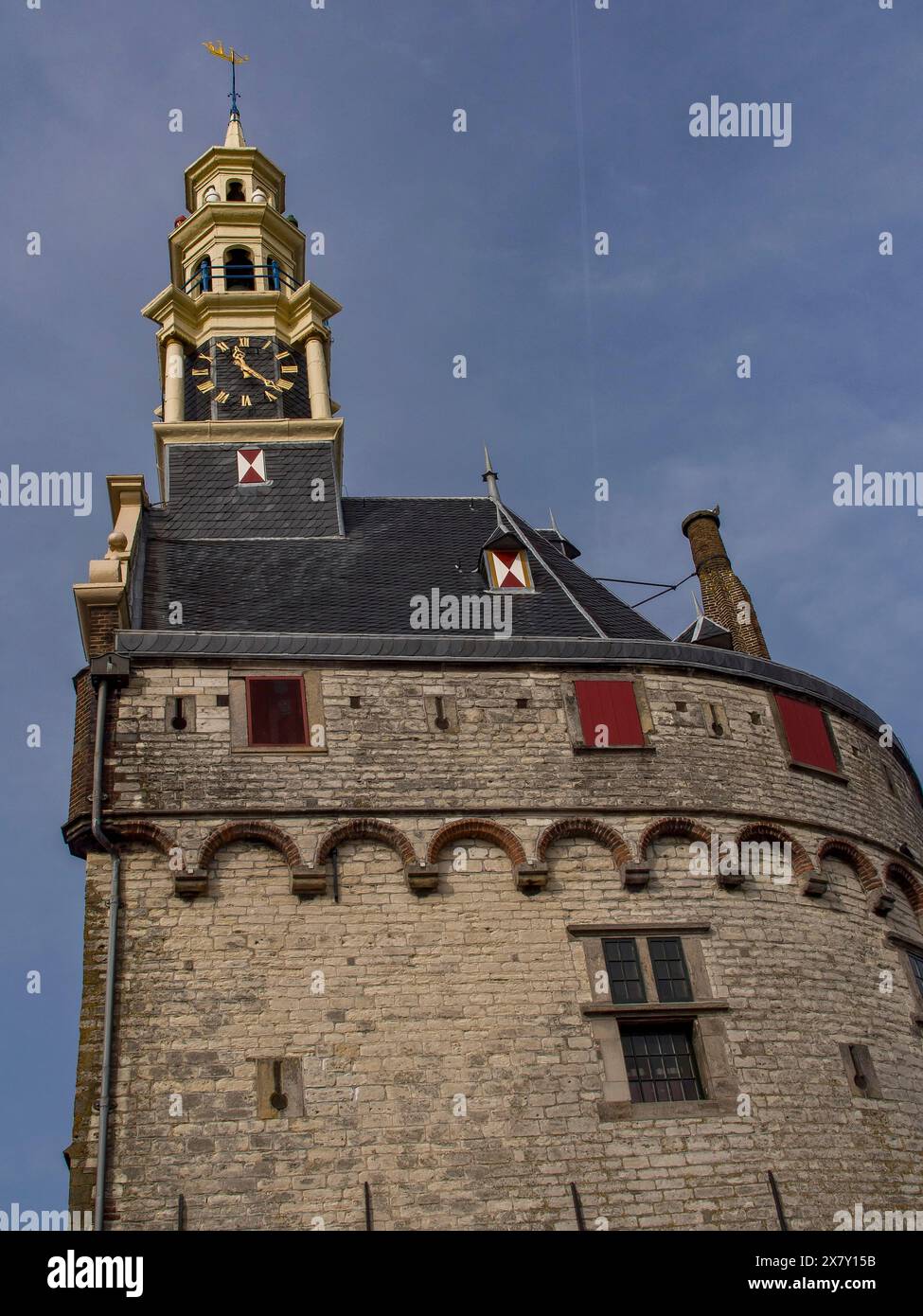 Historic stone clock tower with round superstructure in front of a blue ...