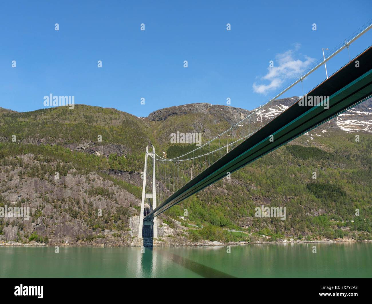 Floating bridge over wooded slopes, under a clear blue sky, bridge in a ...