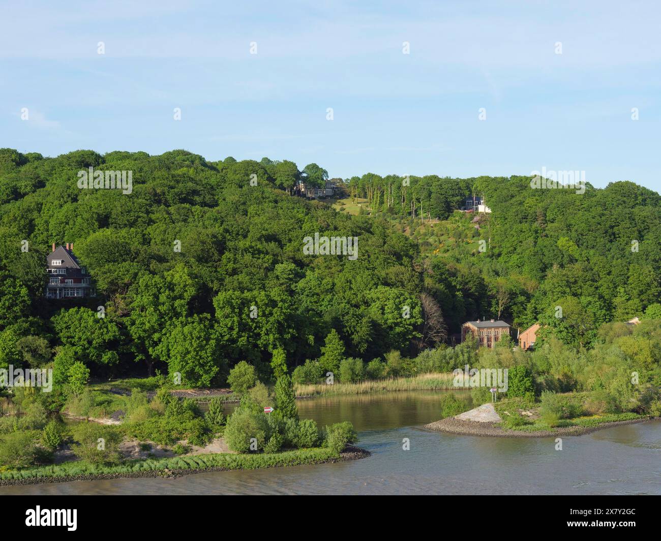 Green wooded hills with scattered buildings and a river in the ...