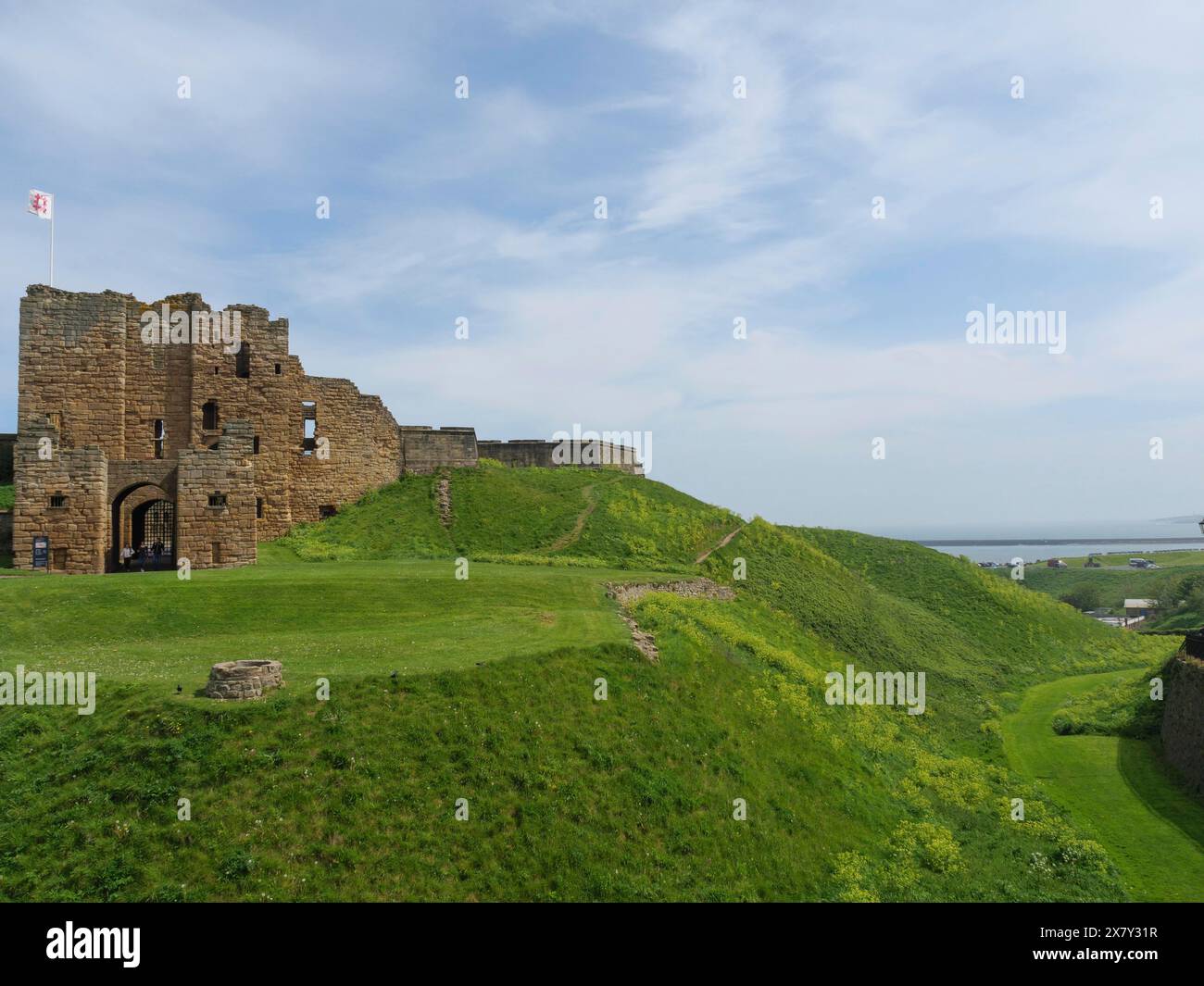 Medieval castle ruins on a green hill overlooking the countryside and ...