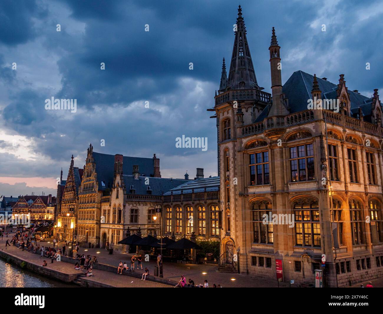 An illuminated gothic cathedral and towers in a park at night, historic ...