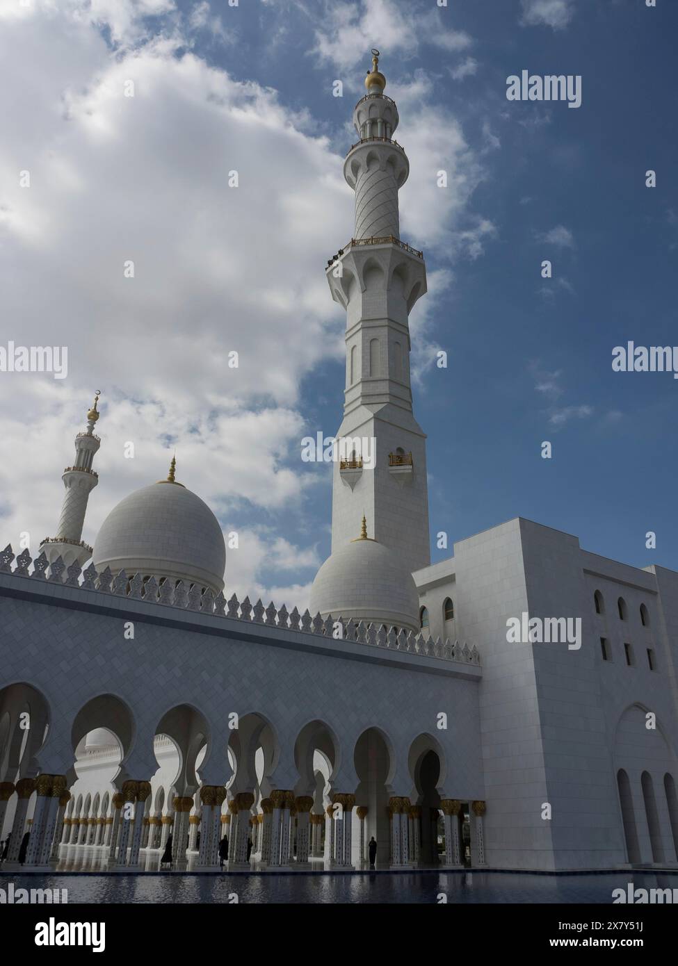 Minaret and domes of the mosque under a slightly cloudy sky, white ...