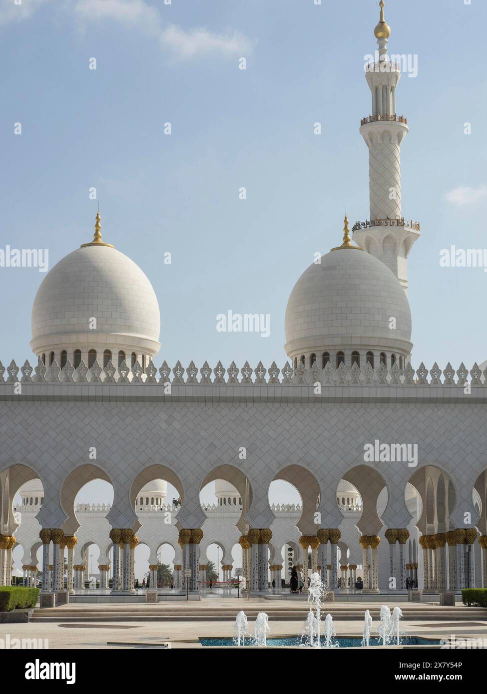 Elegant mosque with striking white domes and a high minaret under a ...