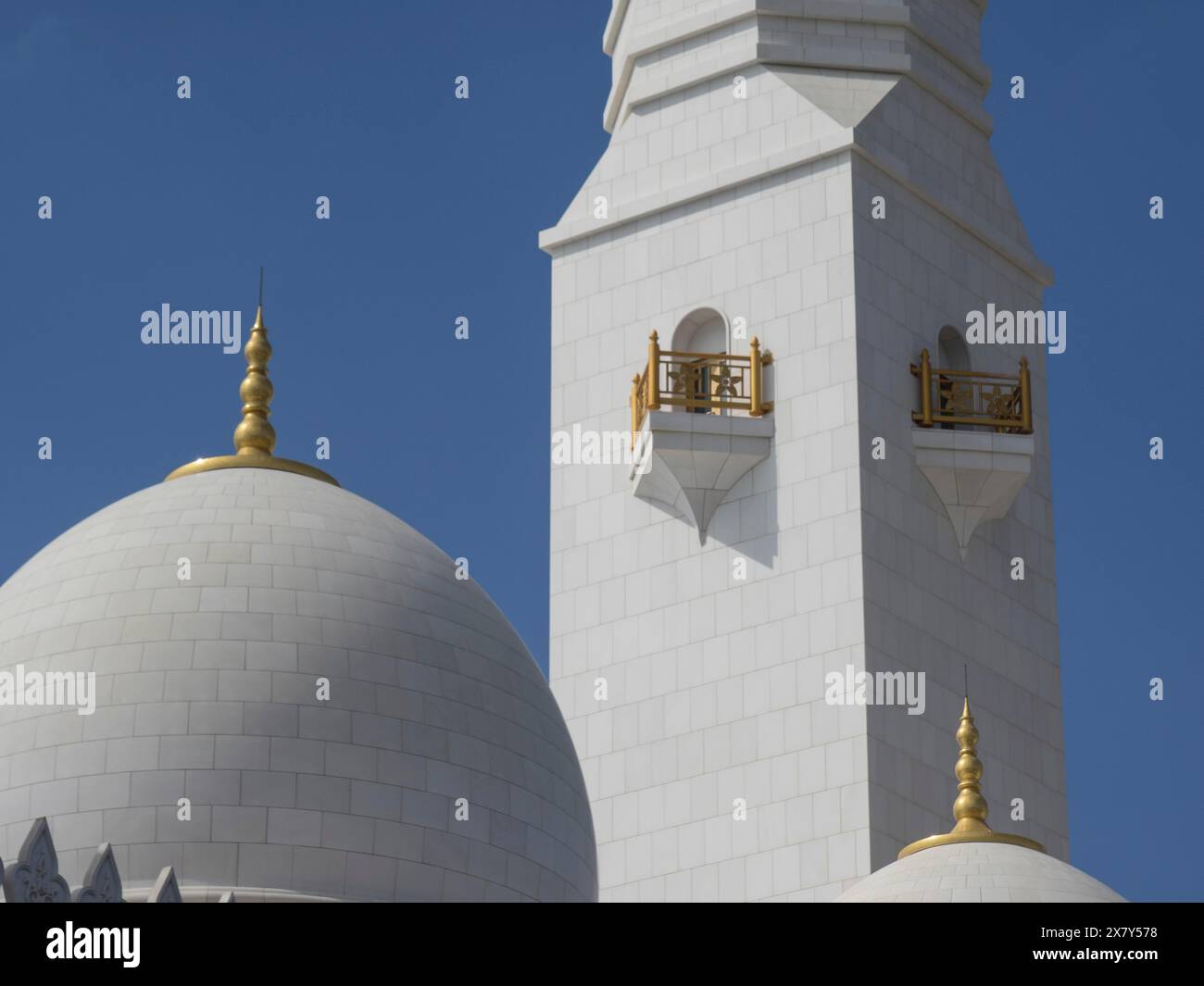 Close-up of a white mosque dome and minaret against a blue sky, white ...