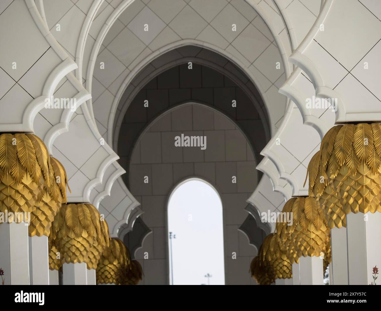 Detailed view of arches and columns with golden decorations in a mosque ...