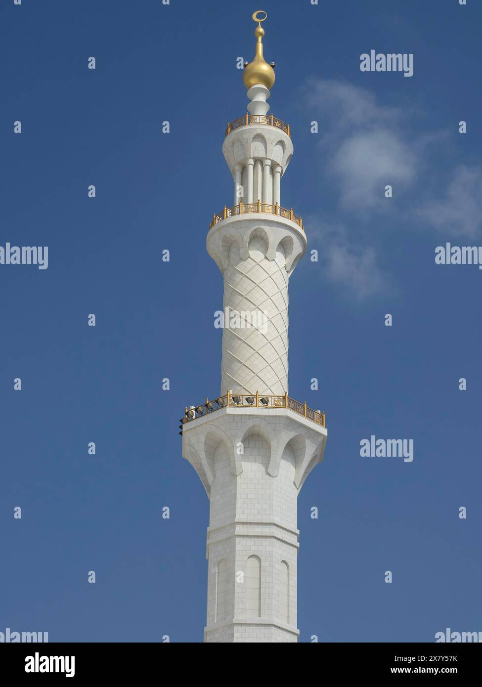 Tall white minaret with golden decorations and clear architectural ...