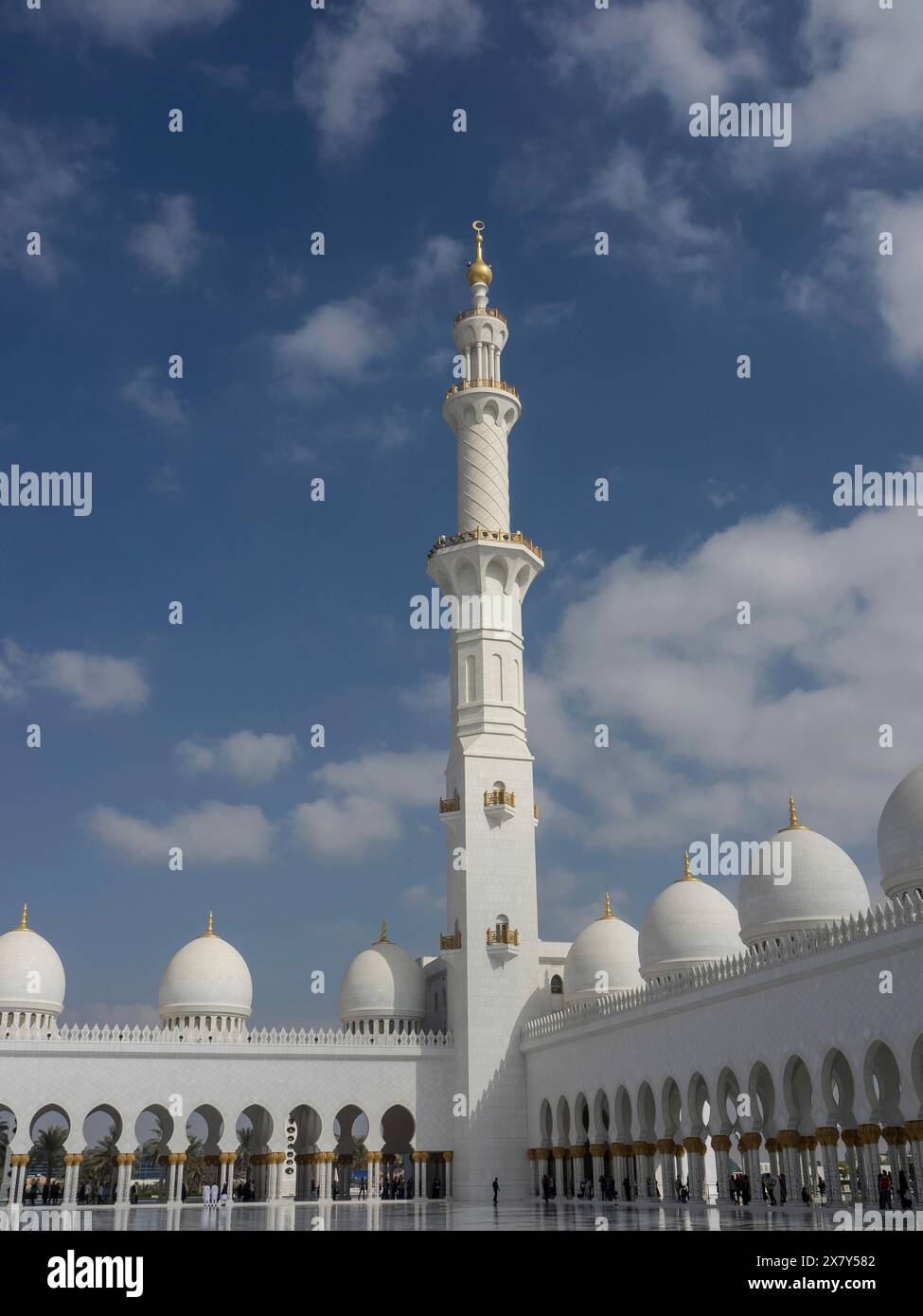 Elegant mosque with high minarets, white domes and golden decorations ...