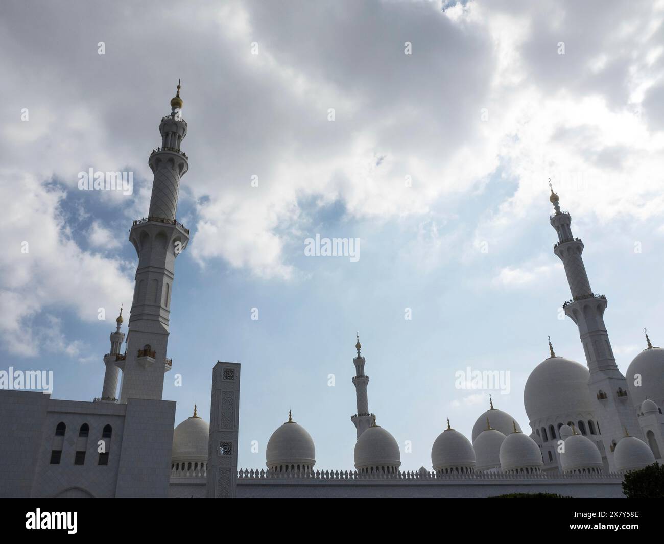 Majestic mosque structure with multiple minarets and domes touching the ...