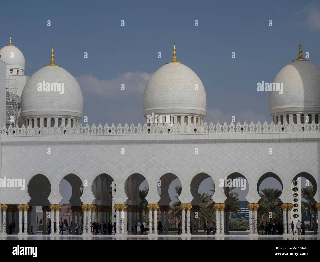 Row of white domes with golden accents and arches, surrounded by palm ...