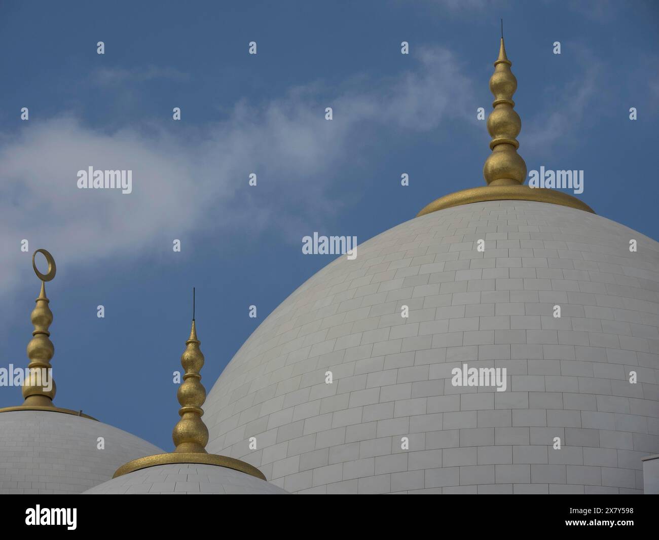 White dome with golden spires against a clear blue sky, white mosque ...