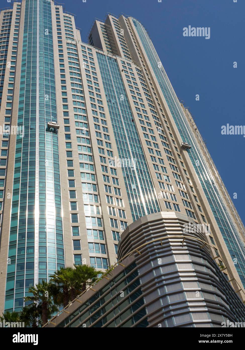 Towering glass facades of modern skyscrapers reaching into the blue sky ...