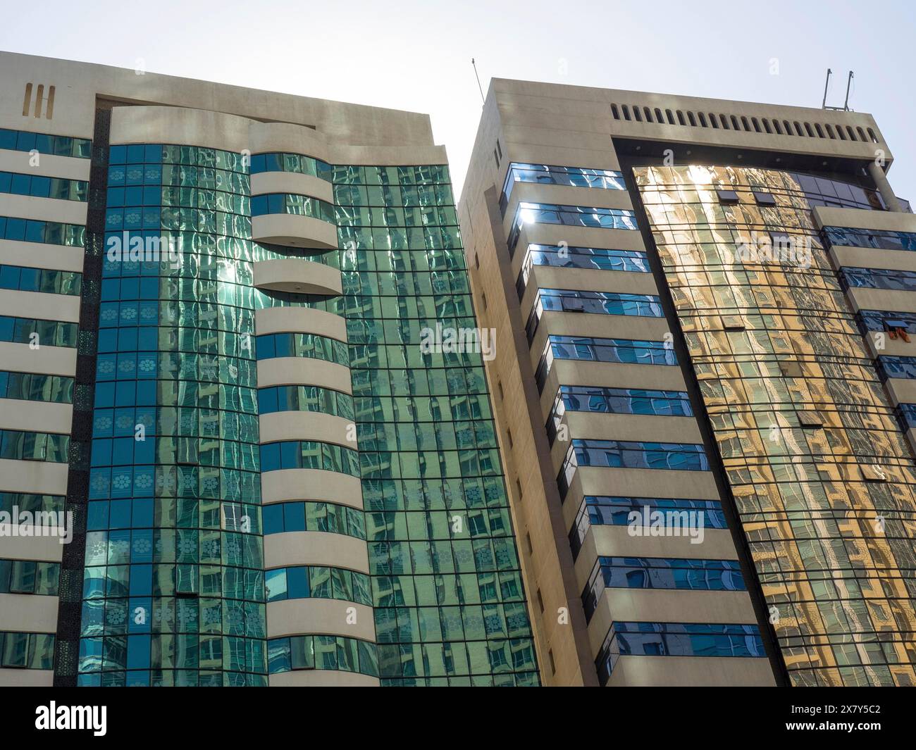 Two modern high-rise buildings with reflective glass facades in the ...