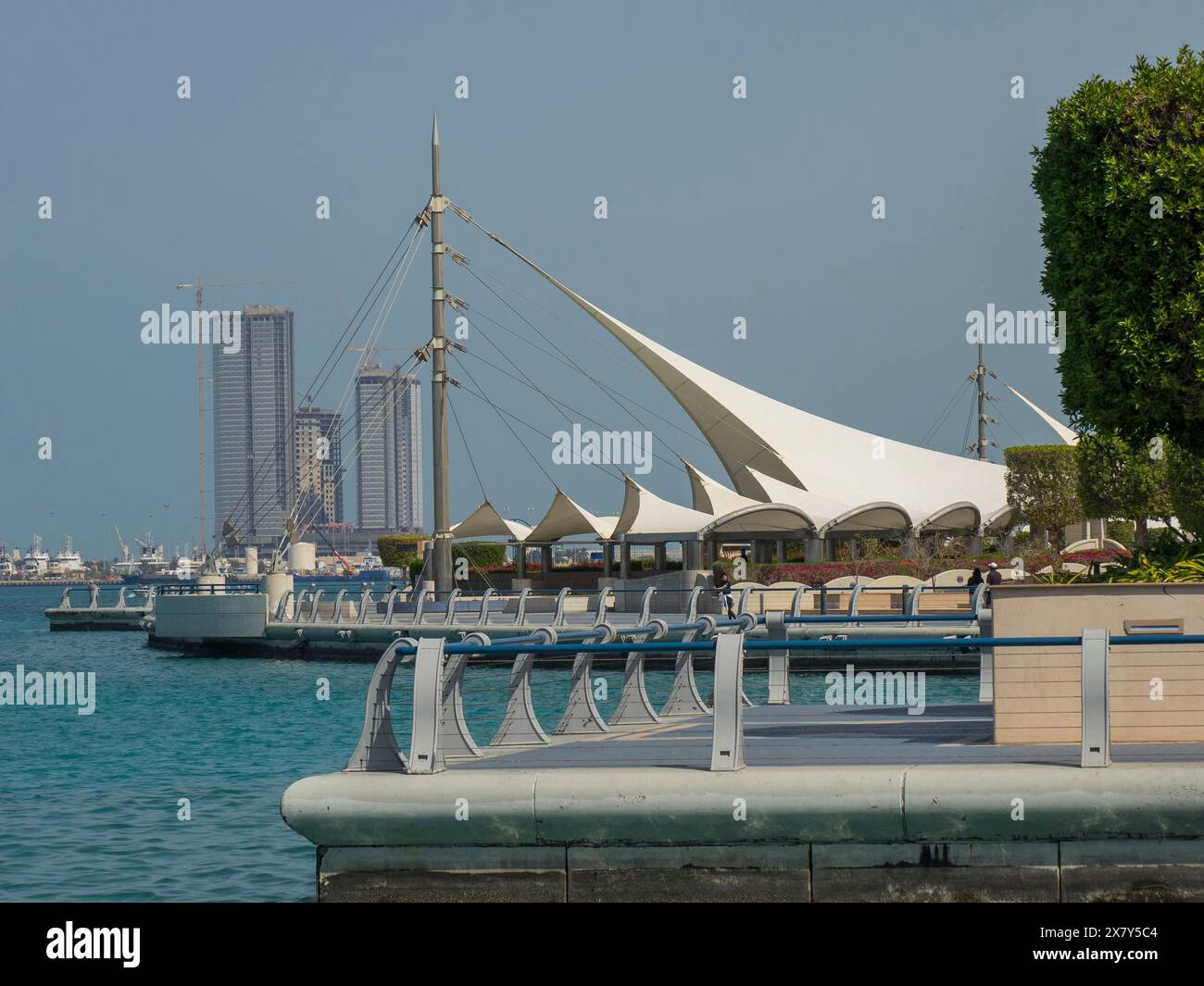 White tent roof next to promenade with modern skyscrapers in the ...