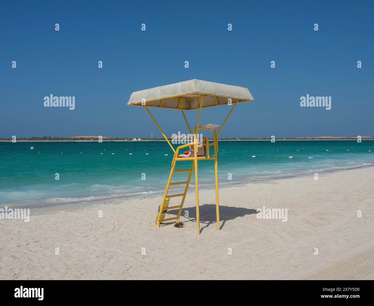 Yellow lifeguard chair on the beach with turquoise water and blue sky ...