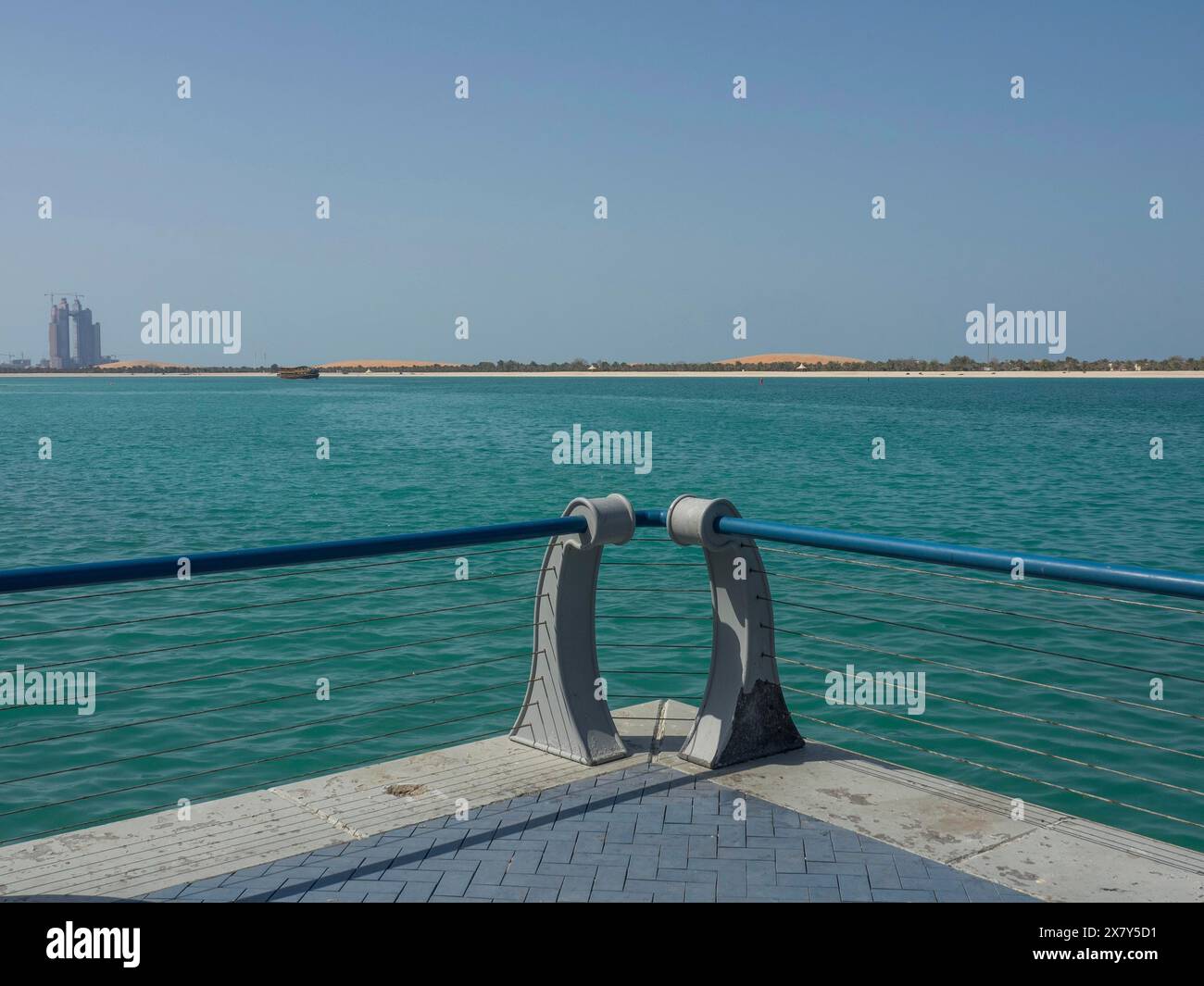 Viewpoint overlooking the calm blue sea and distant waterfront, palm ...