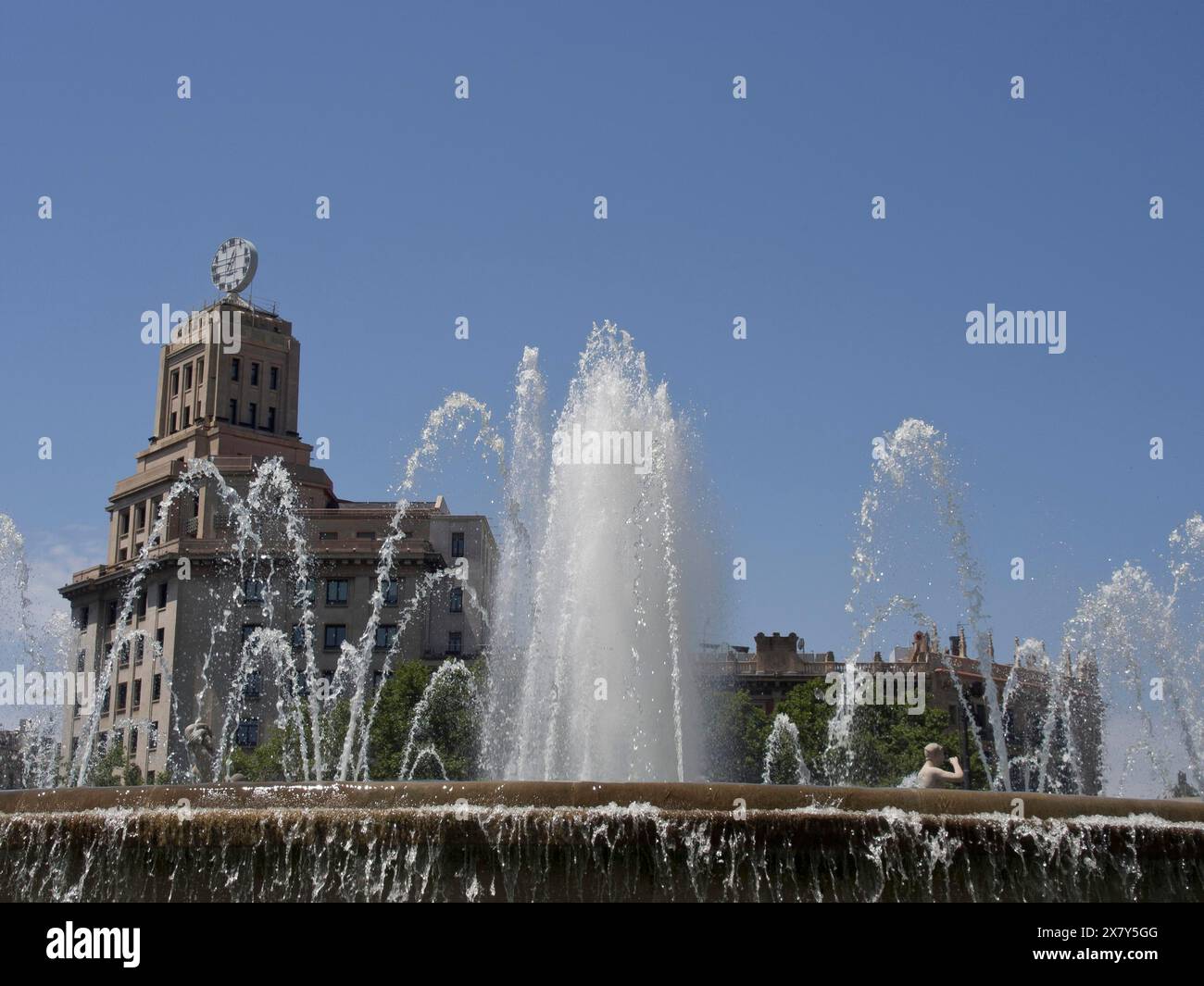A fountain with powerful water jets in front of a historic building ...