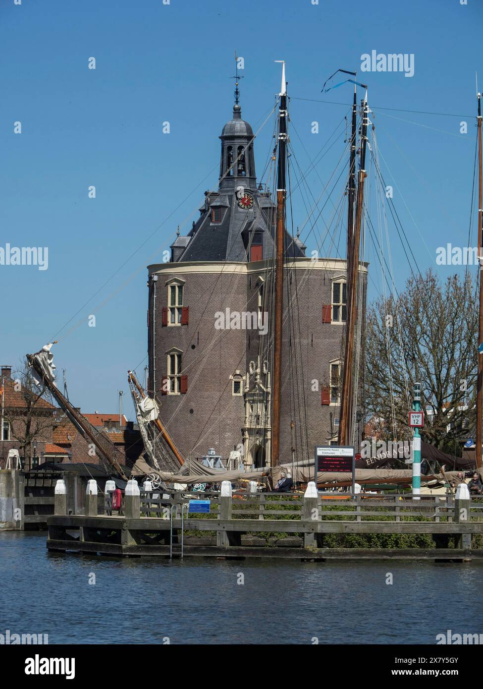 Historic building flanked by ships with high masts reflecting the calm ...