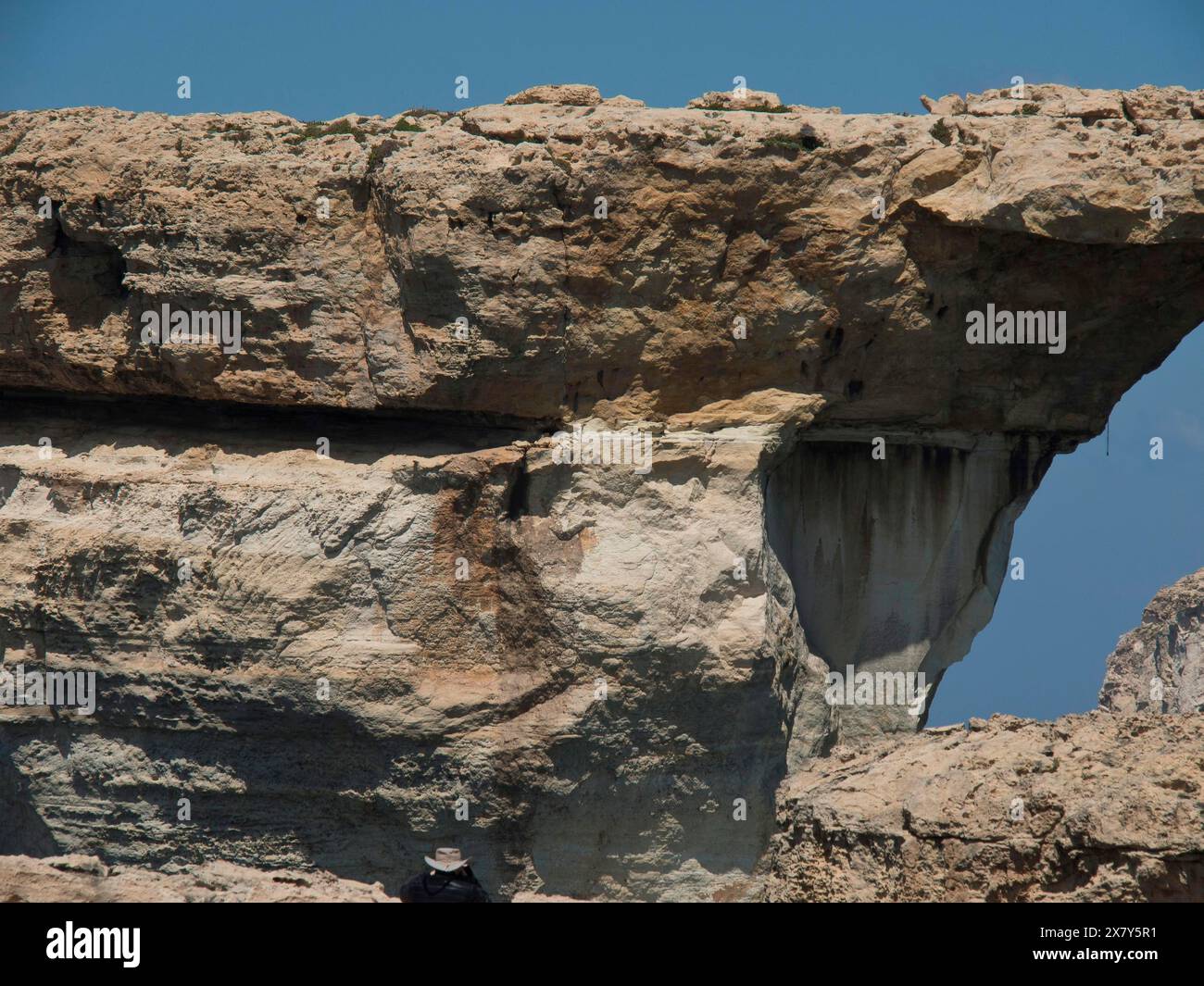 Large rock formation with natural erosion features under a blue sky ...