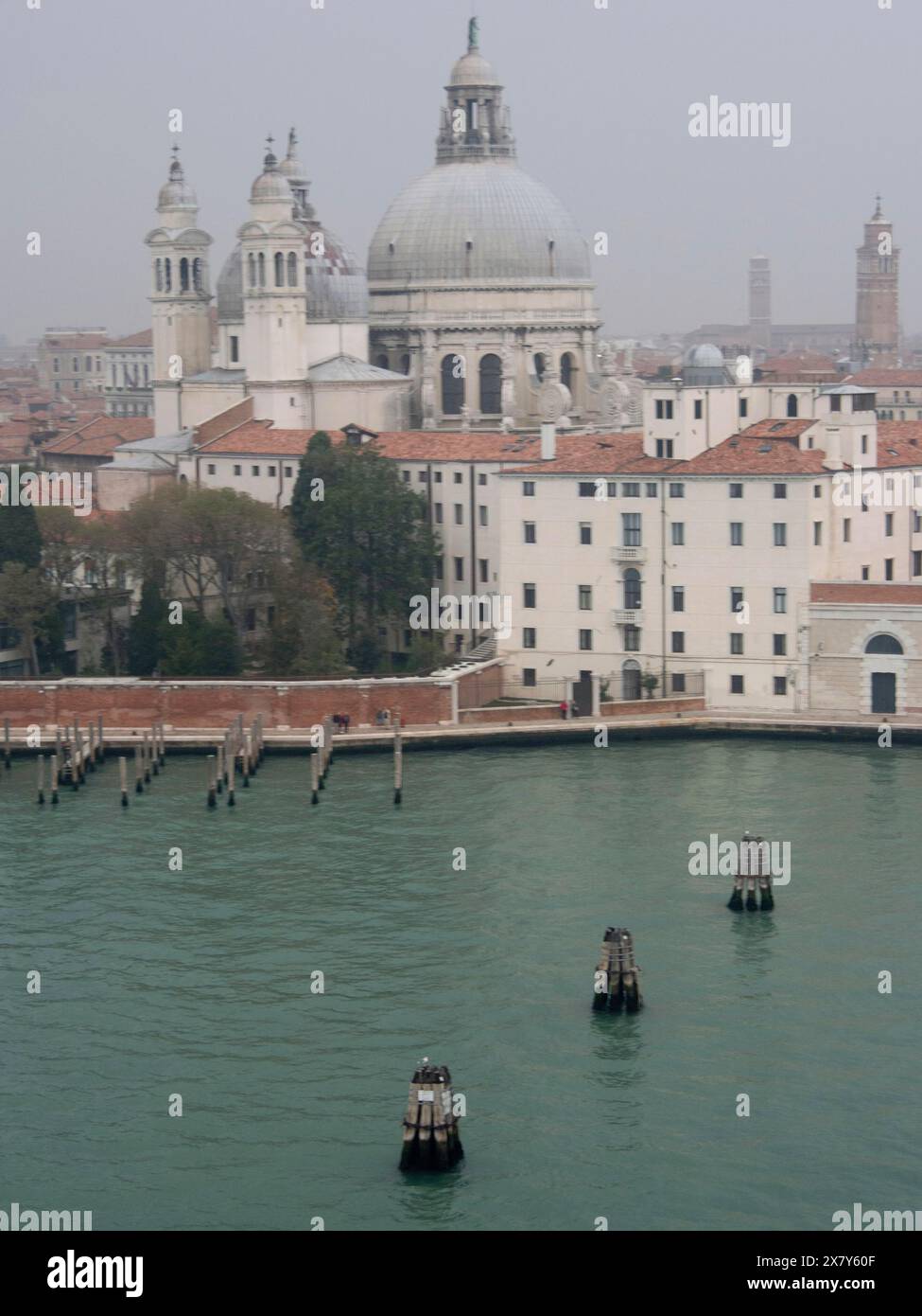 Historic Venetian buildings with domes and water, in a misty atmosphere ...