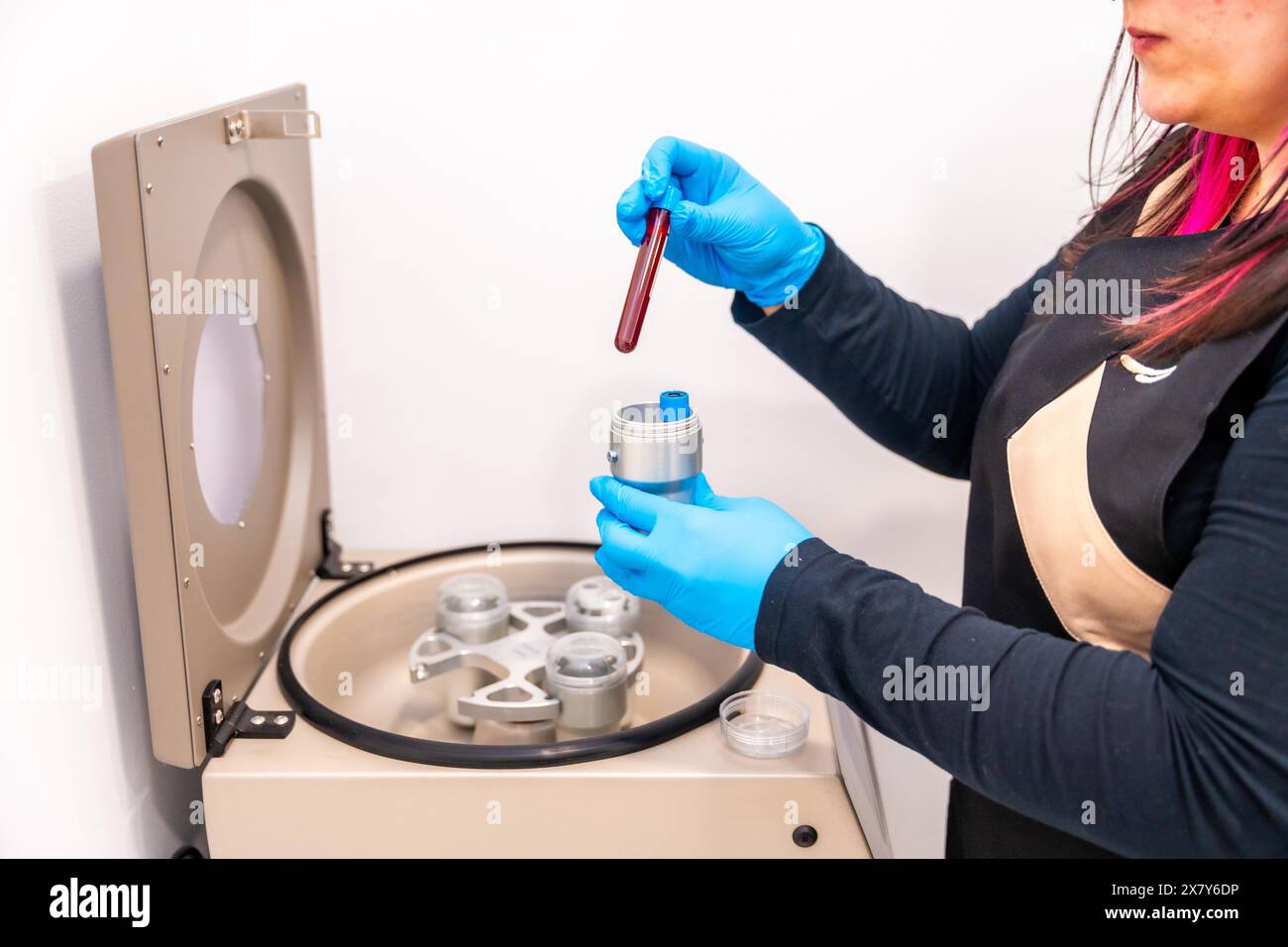 Close-up side view of a professional placing tubes with blood samples in a centrifuge Stock ...