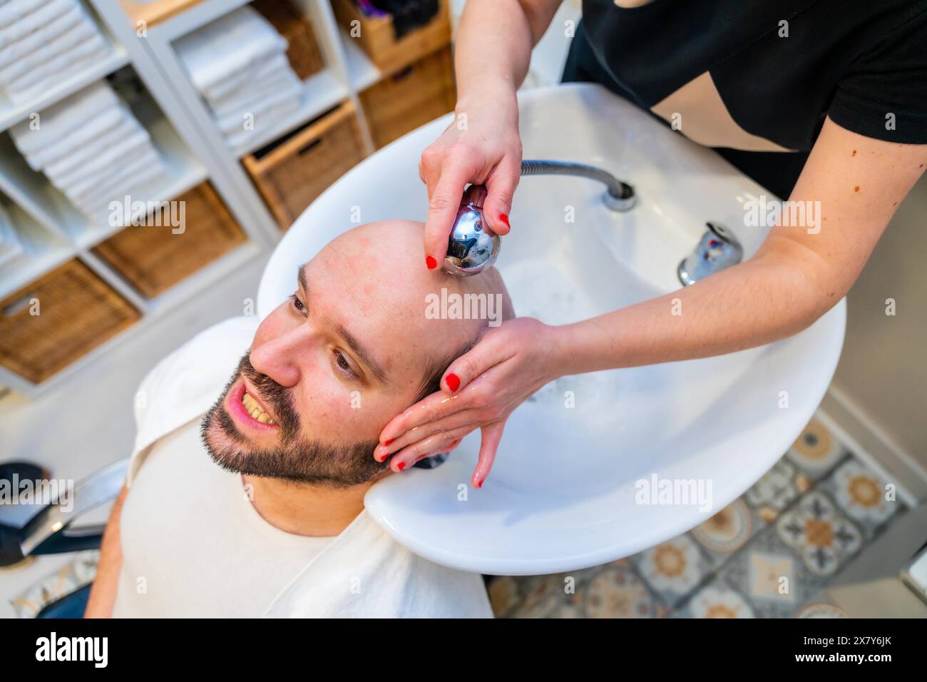 Hairdresser cleaning the head of a bald man in the salon Stock Photo ...
