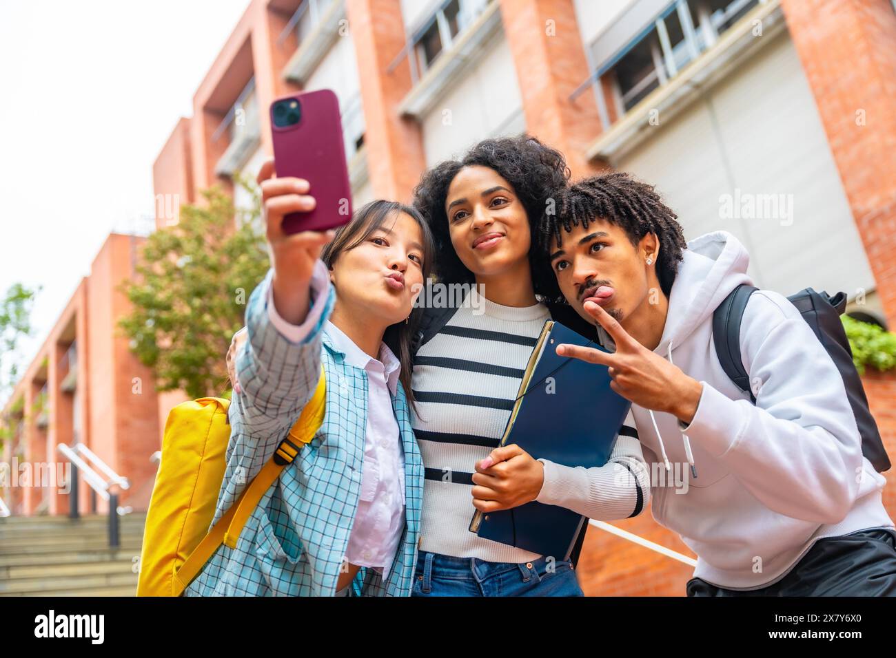 Low angle view portrait of three happy multiracial university students ...