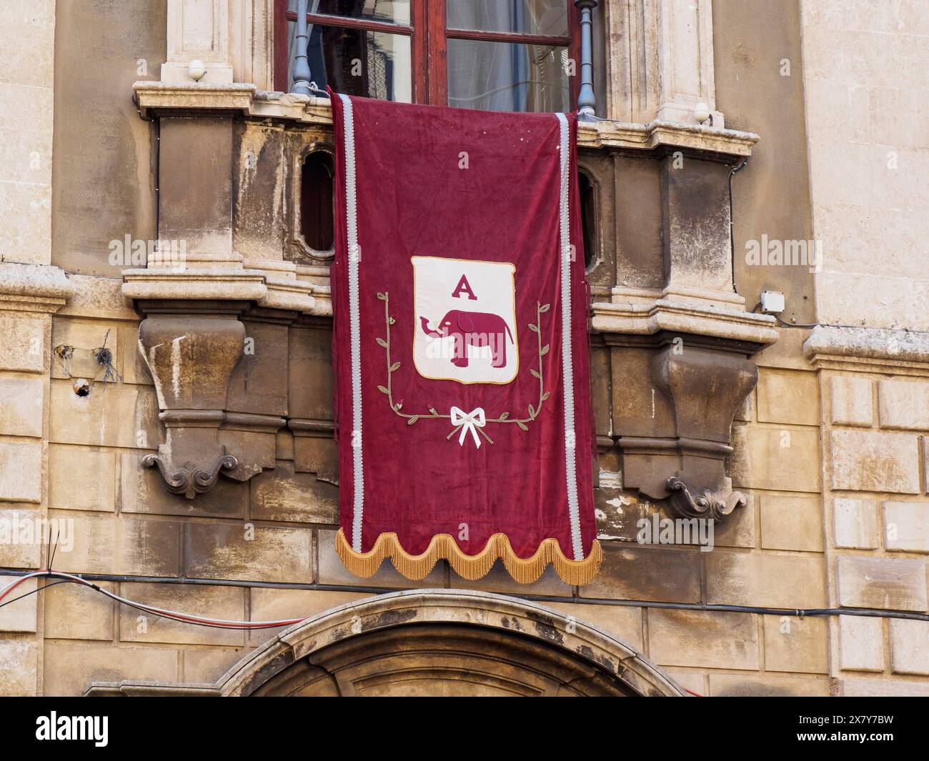 Red banner with an elephant symbol draped over a medieval building ...