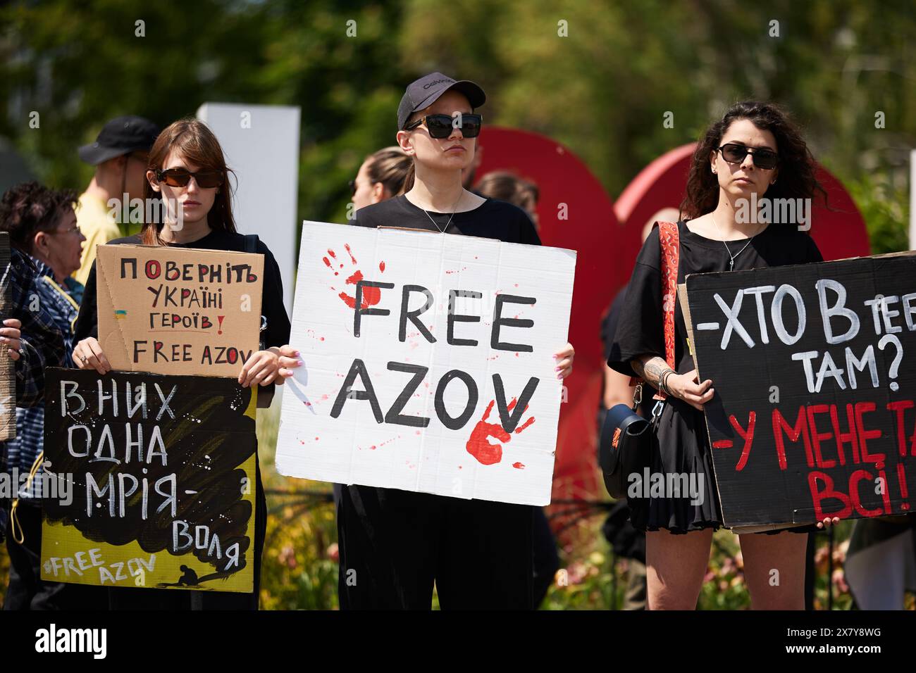 Ukrainian women posing with banners "Free Azov" on a public ...