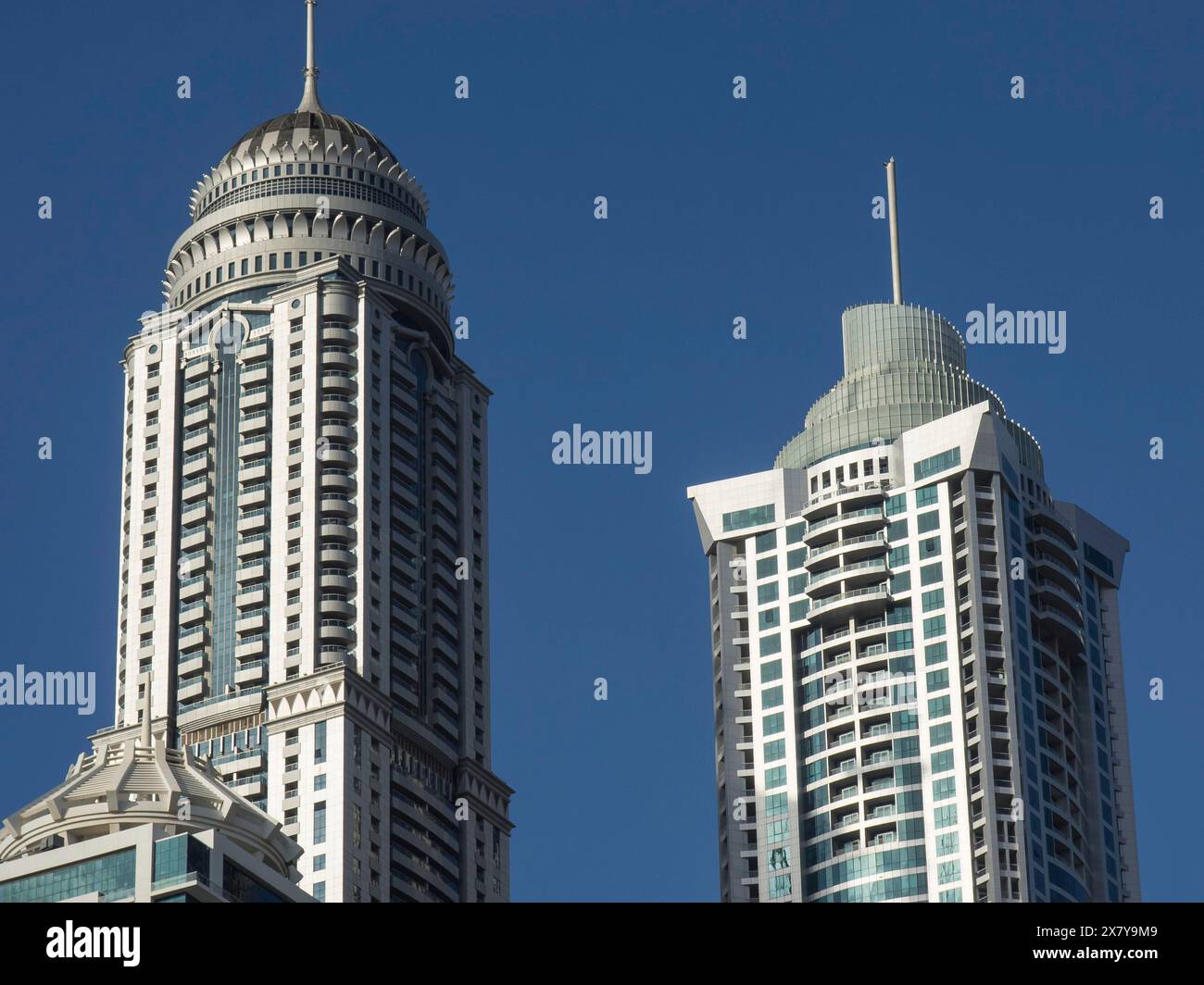 Two towering buildings with modern glass facades against a clear blue ...