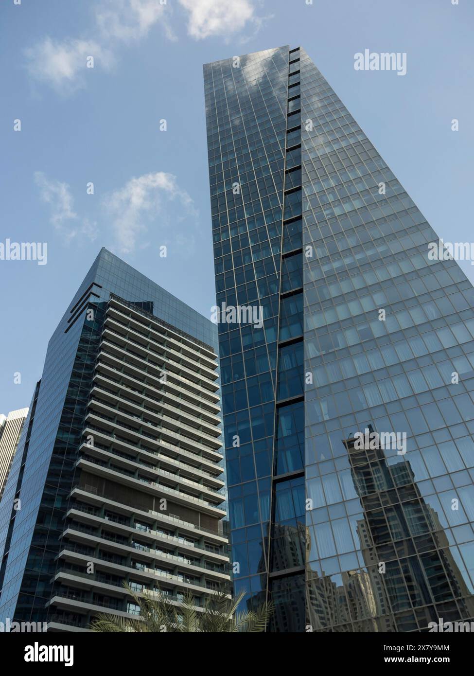 Two towering modern skyscrapers with glass facades against a clear blue ...