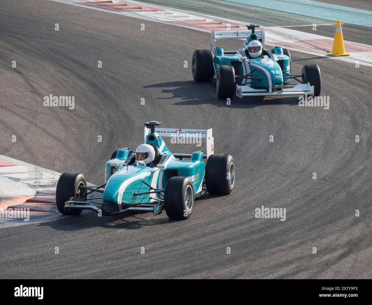 Two racing cars driving close together at high speed round a curve ...