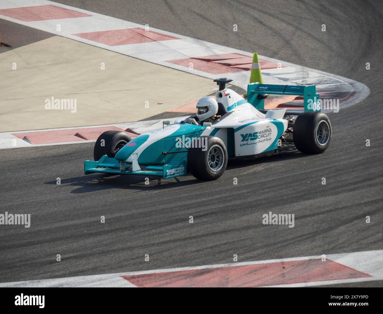 A racing car takes a sharp turn on the race track while the driver is ...