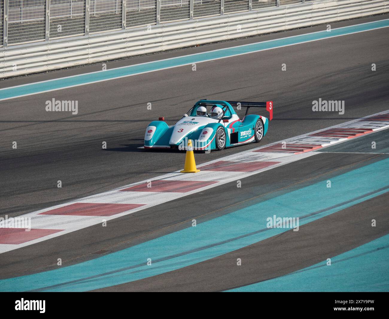 A racing car on a tarmac track passing a curve, accompanied by speed ...