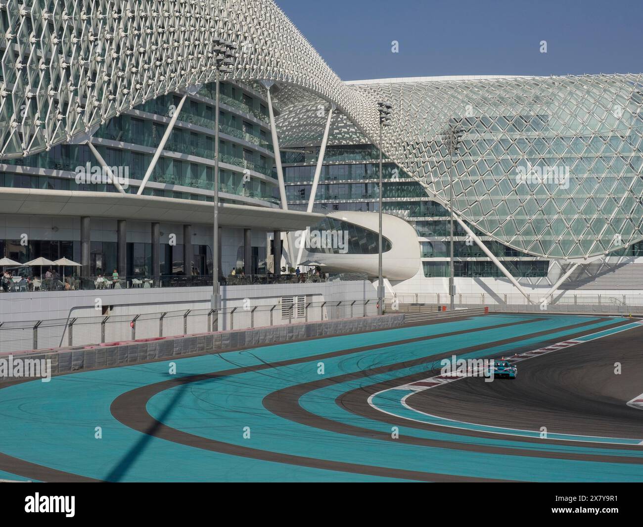 Single racing car on a curvy race track with modern building in the ...