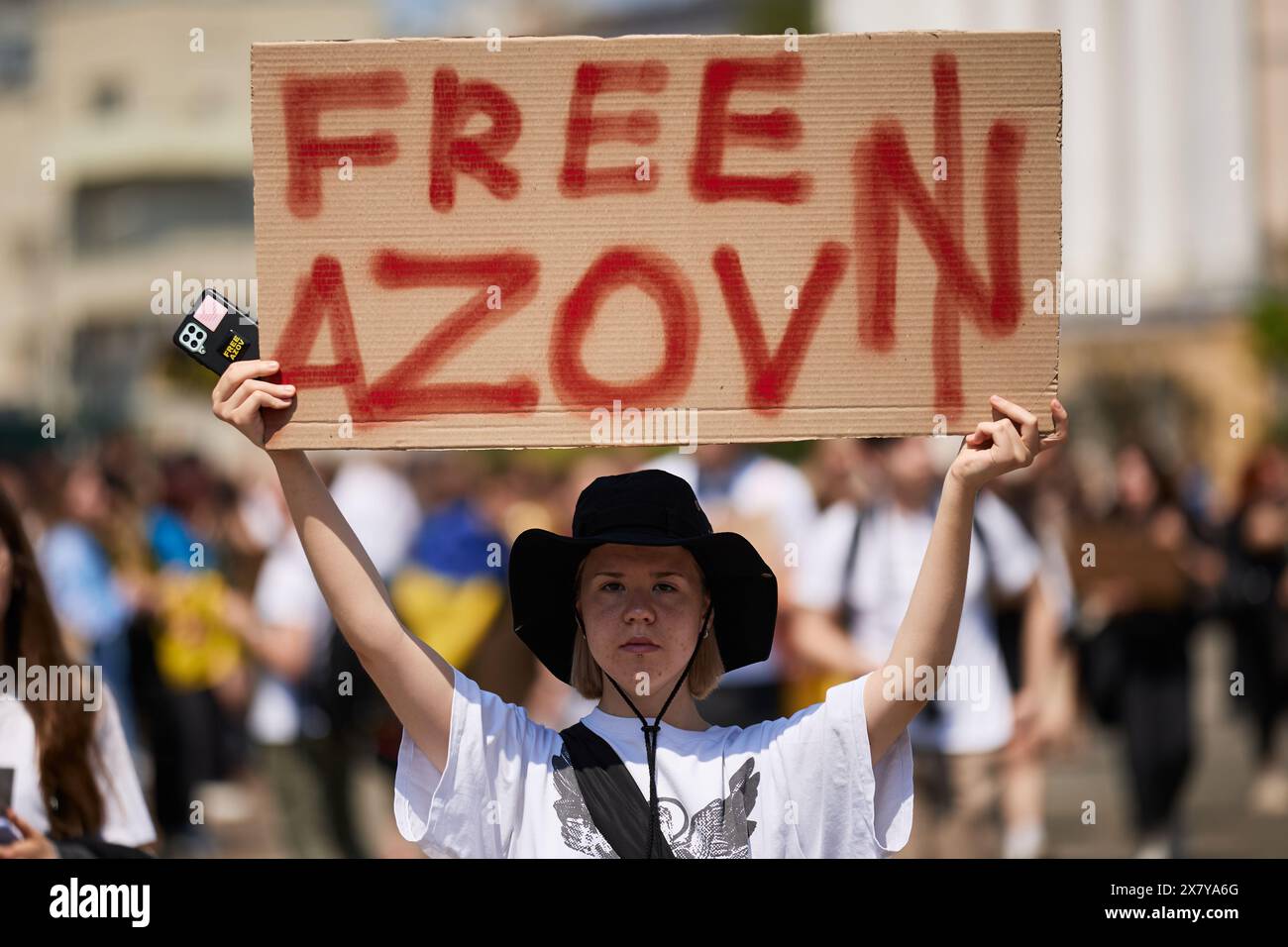 Young Ukrainian girl posing with a banner "Free Azov" and a logo o Azov ...