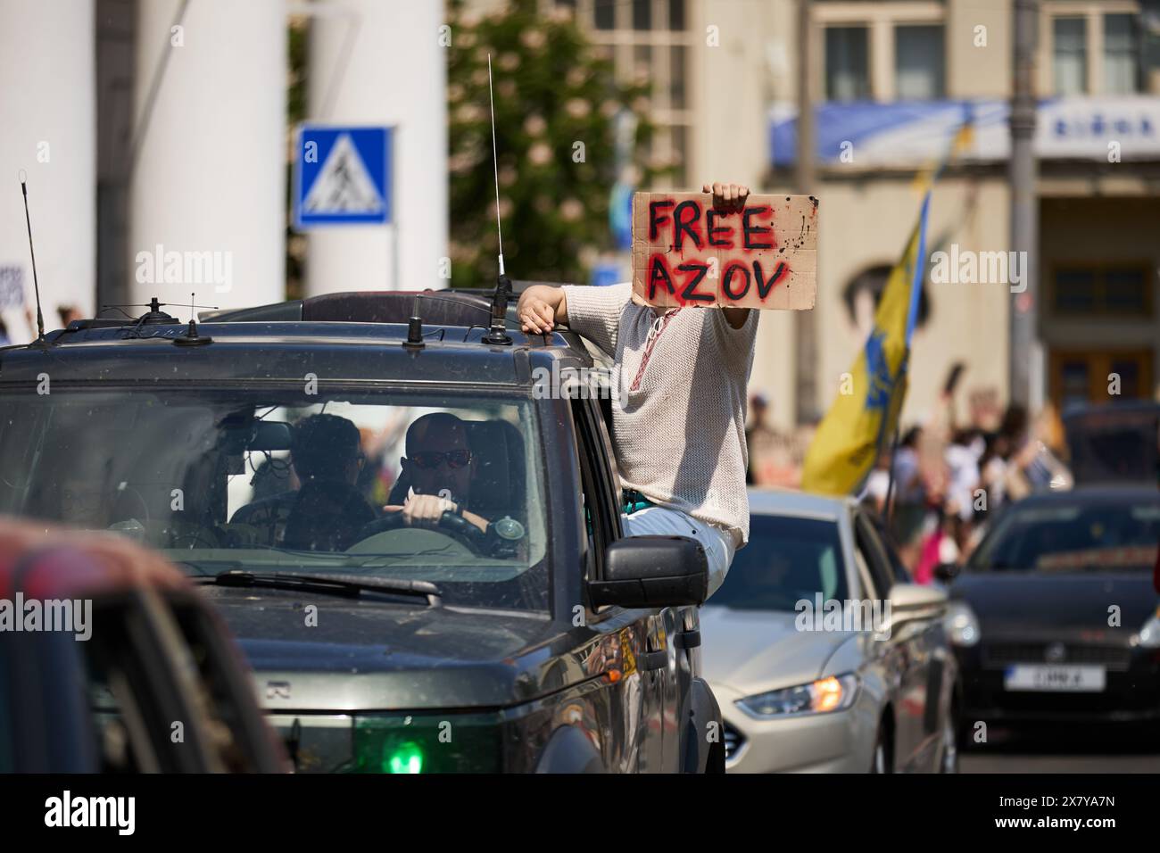 Activist shows a sign "Free Azov" out of a car window during the ...