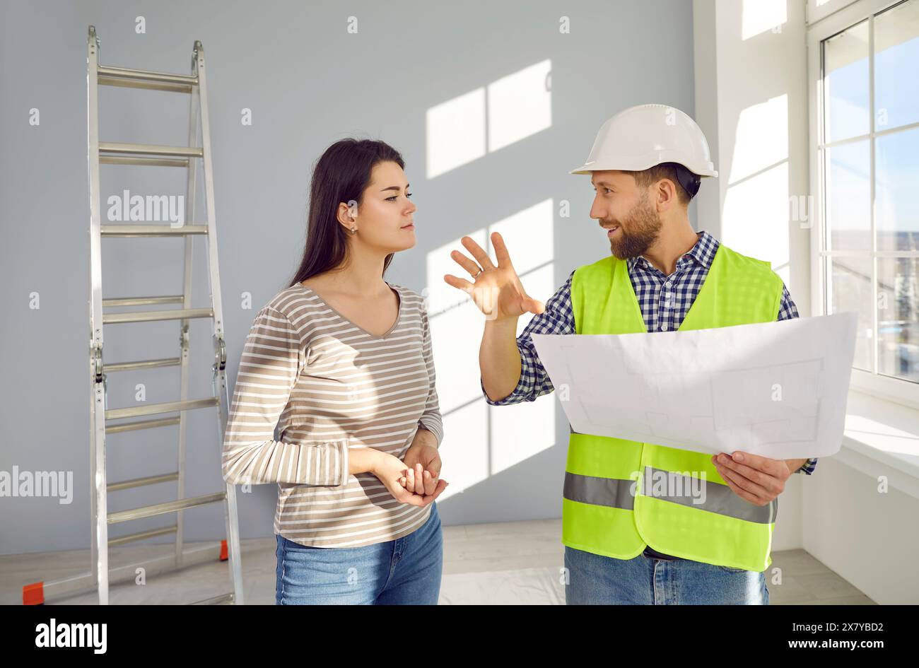 Meeting of pretty female homeowner and attractive, smiling foreman for ...
