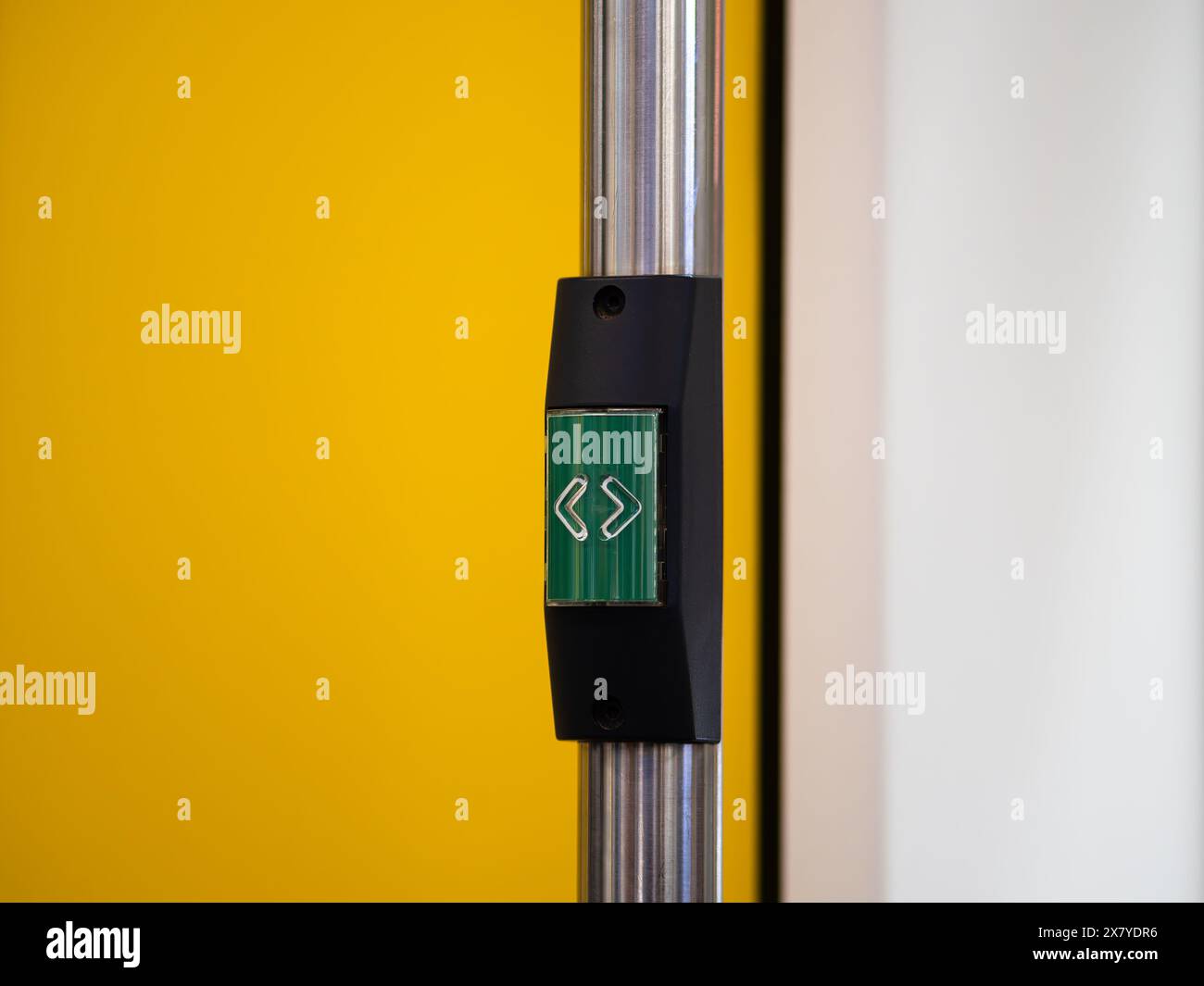 This image features a metallic pole with a black and green door open ...
