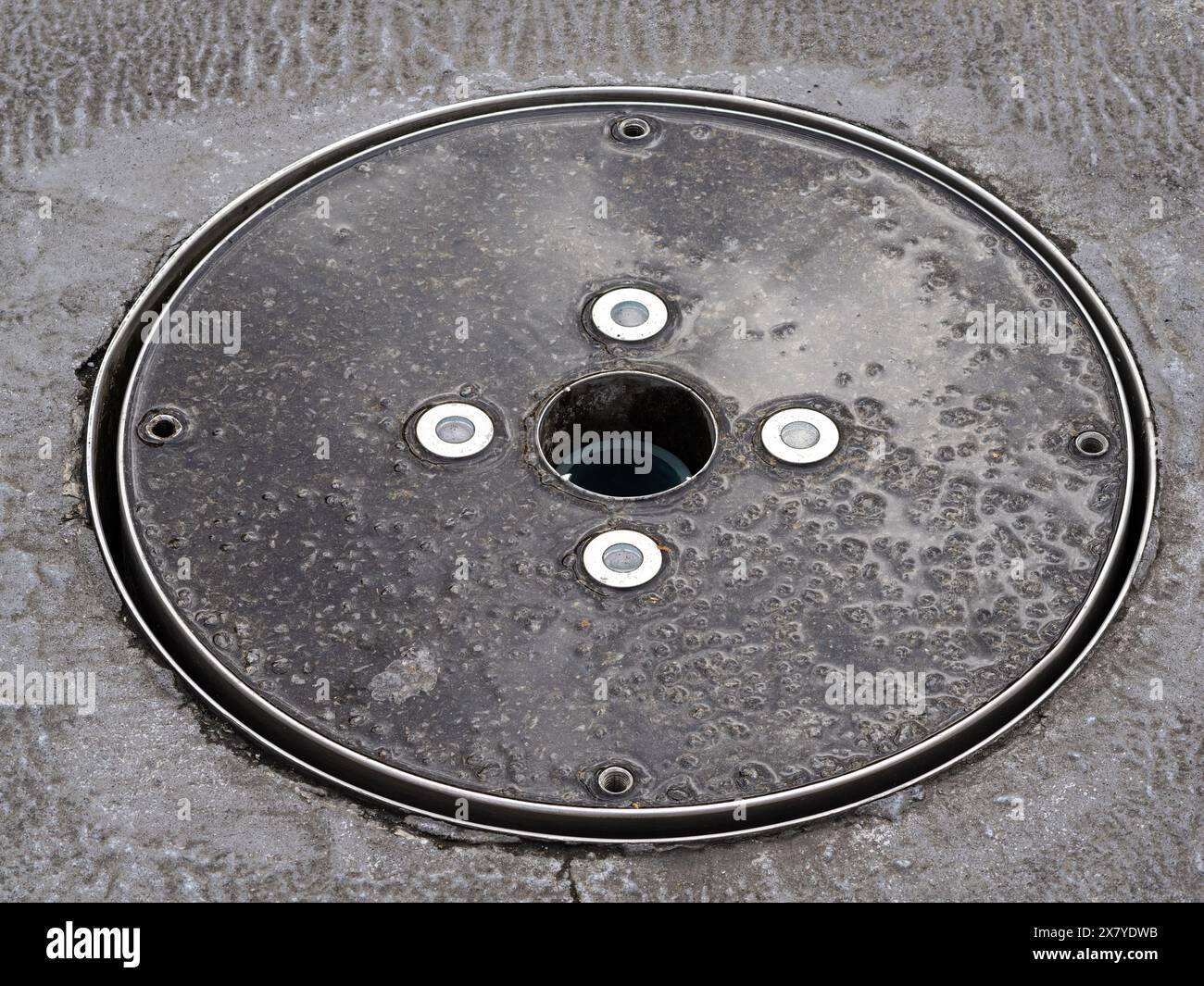 Close-up of weathered metal manhole cover in urban setting, textured ...