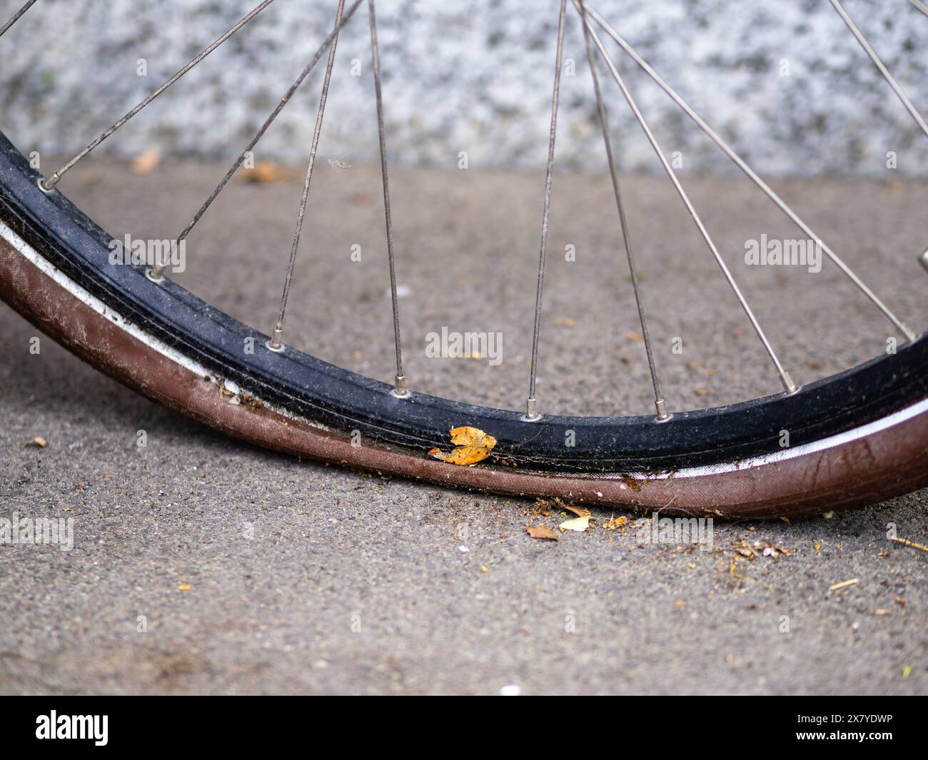 Close-up of a deflated bicycle tire on a concrete surface outdoors ...