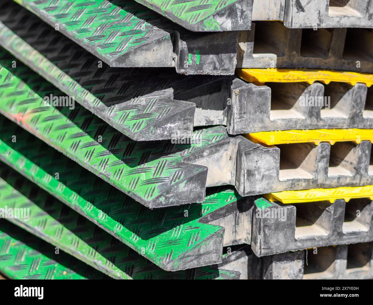 A stack of interlocking green and yellow panels with diamond plate ...
